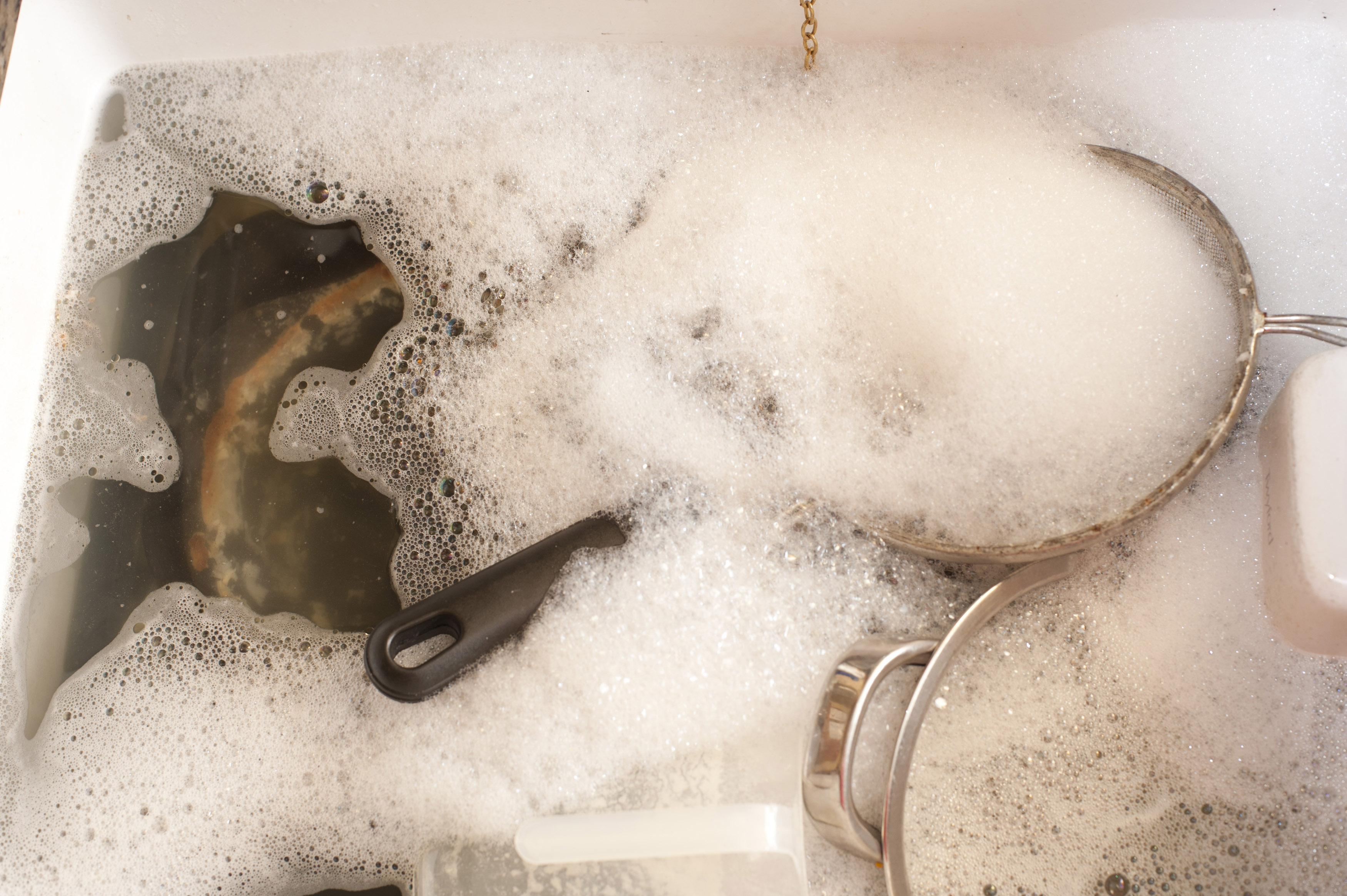 Dirty pots and pans soaking in soapy water - Free Stock Image